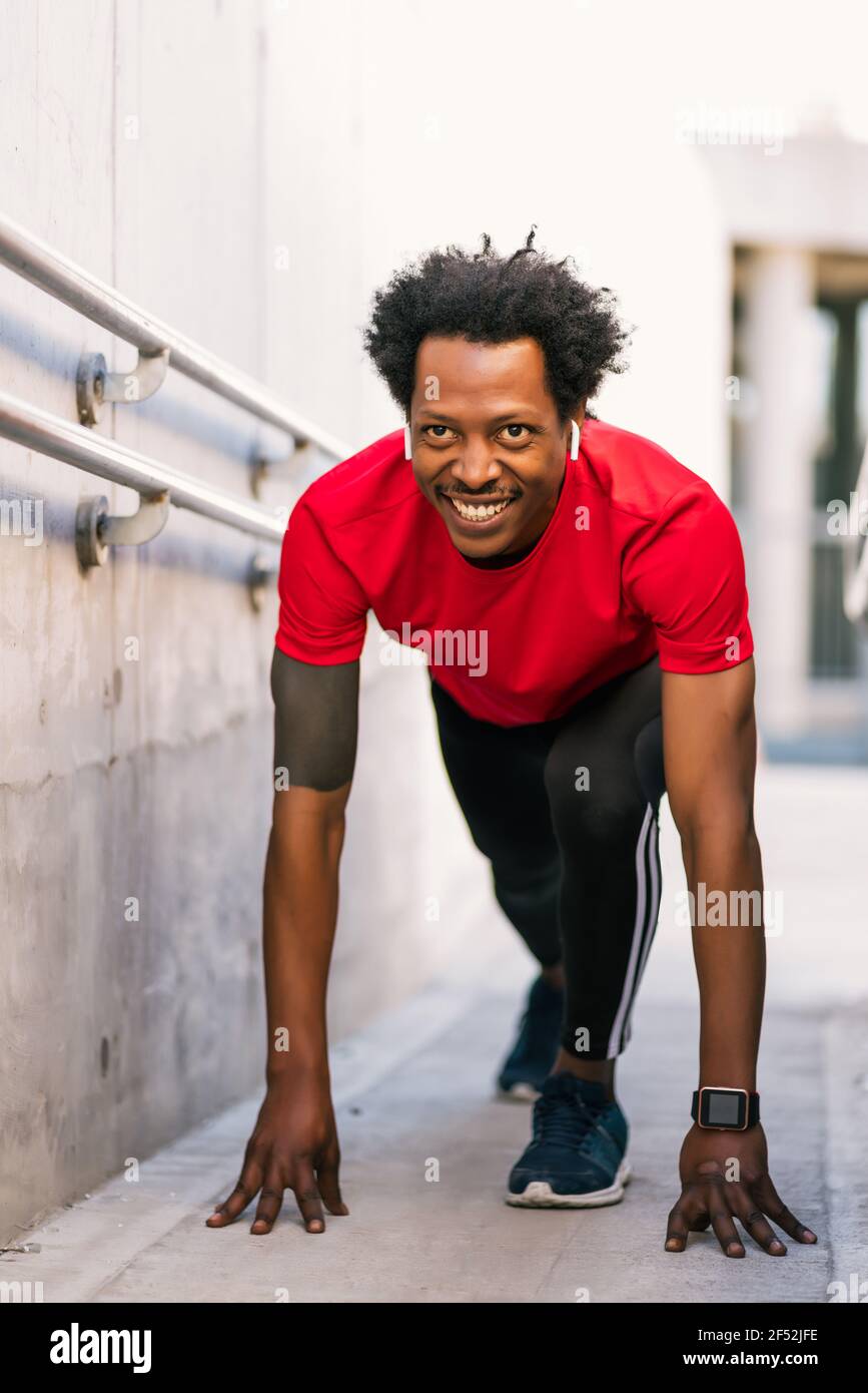 Athlete man in start position preparing to run outdoors Stock Photo - Alamy