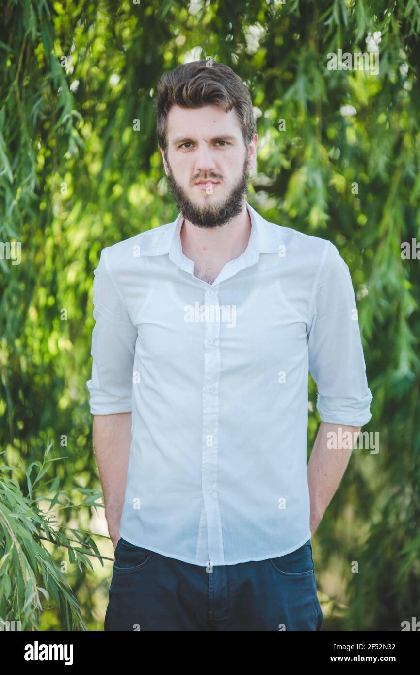 Shallow focus shot of a Bosnian Caucasian man standing against a blurred green background Stock ...