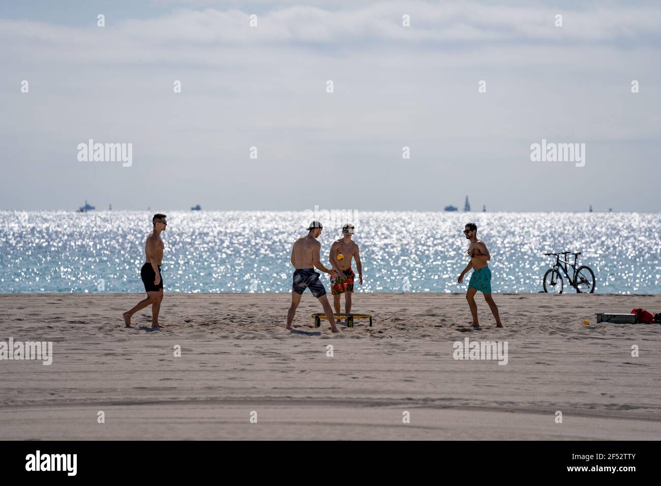 College guys playing spikeball on the beach during Spring Break Miami ...
