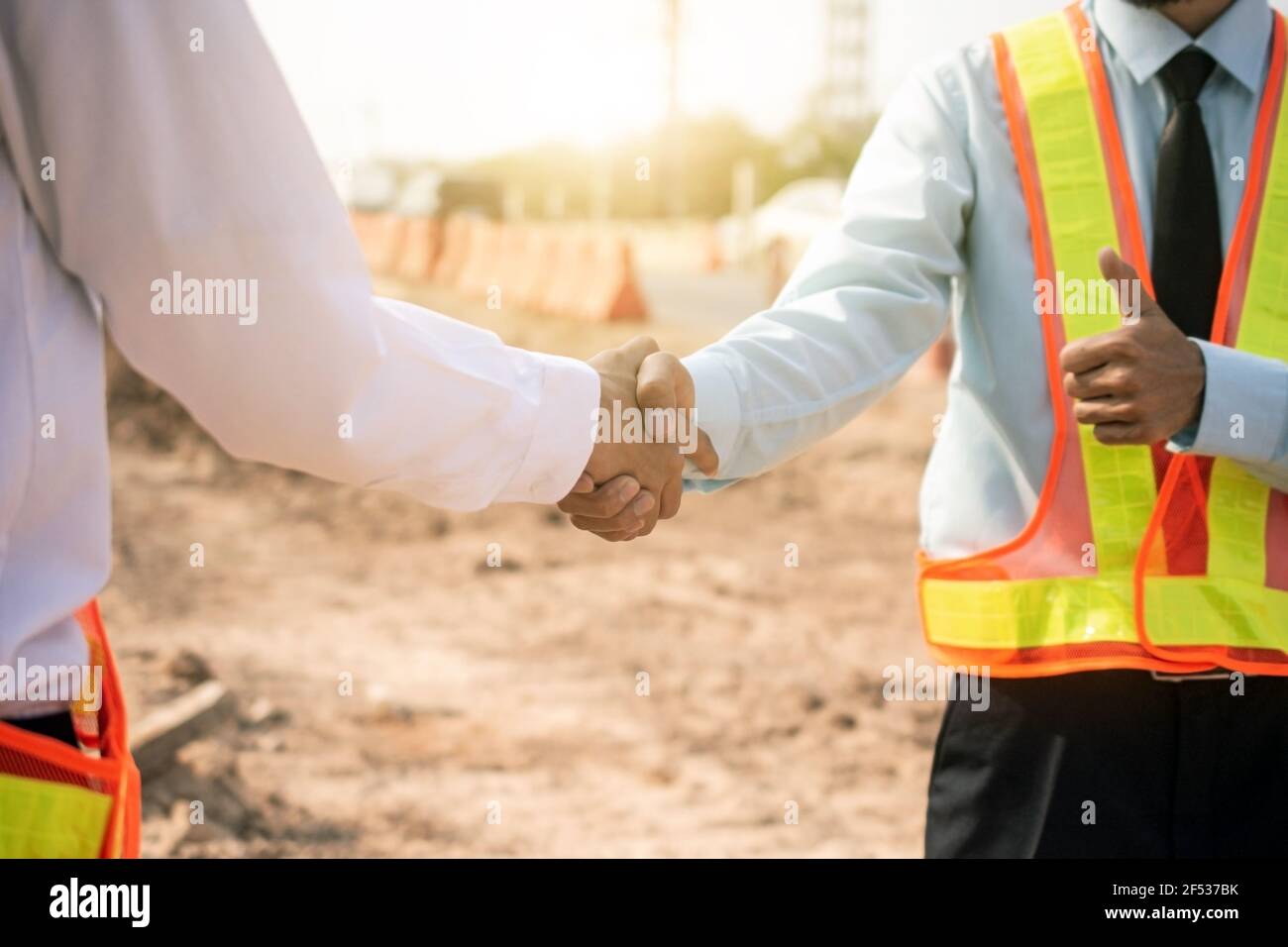 Engineer teamwork shake hand on site construction Stock Photo - Alamy