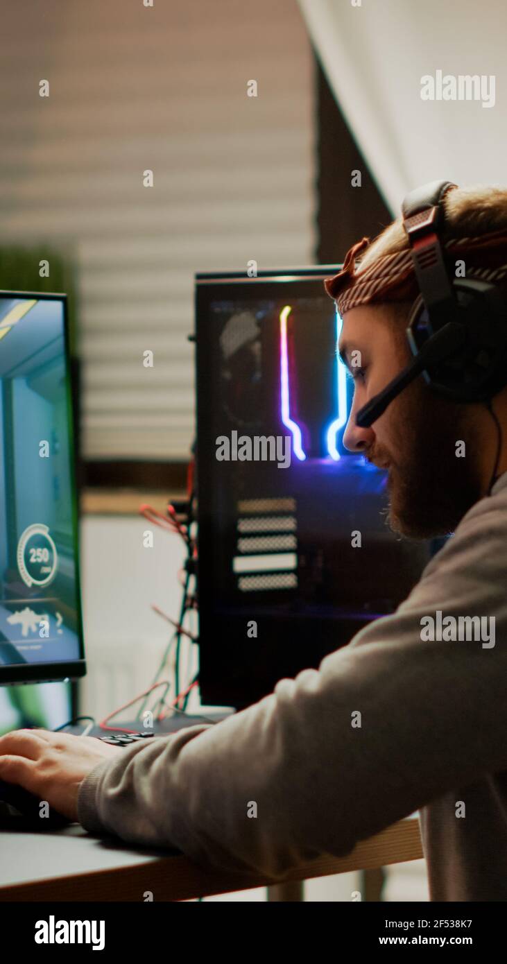 Cyber sport gamer wearing headphones playing first person shooter ...