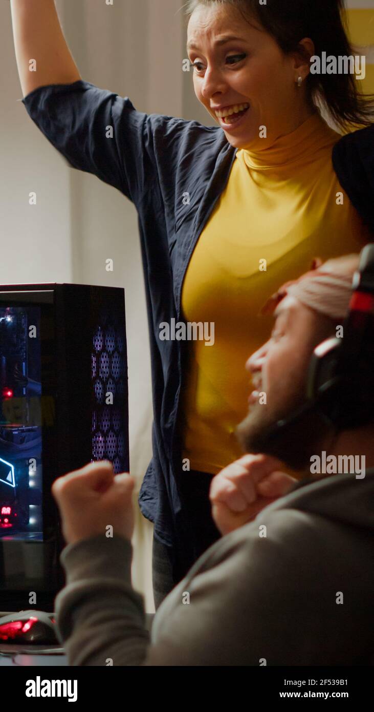 Excited couple gamer winning first person shooter online video game on ...