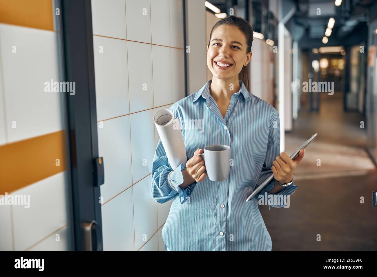 Lady engineer standing in the corridor during the coffee break Stock ...