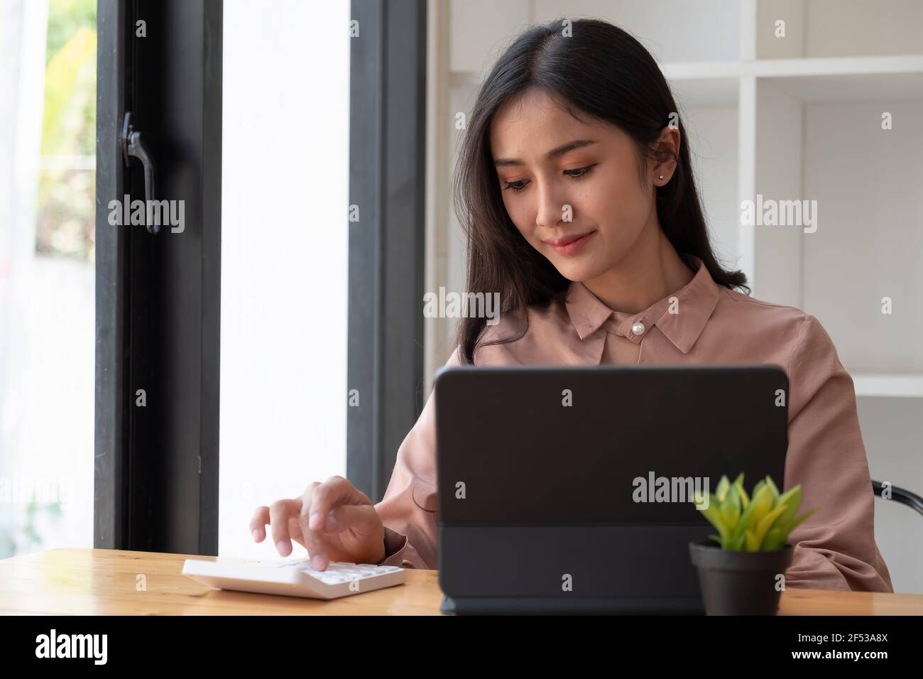 Shot of accountant working on desk office with using a calculator to ...