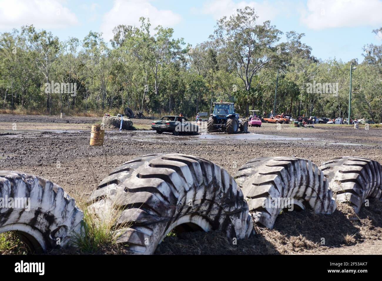 A vehicle bogged in the mud at the mud races being pulled out by a ...