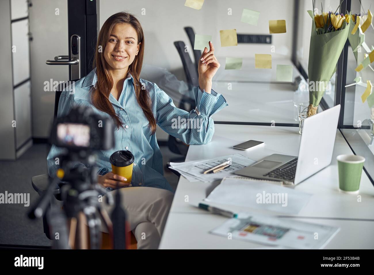 Smiling vlogger streaming a live video from her office Stock Photo - Alamy