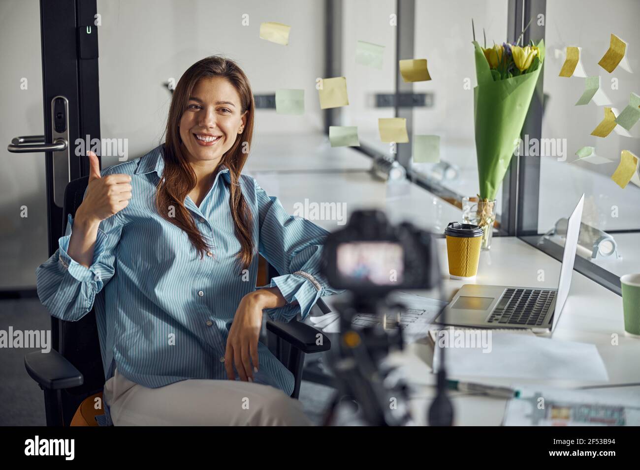 Smiling vlogger showing a thumb-up gesture in front of the camera Stock ...