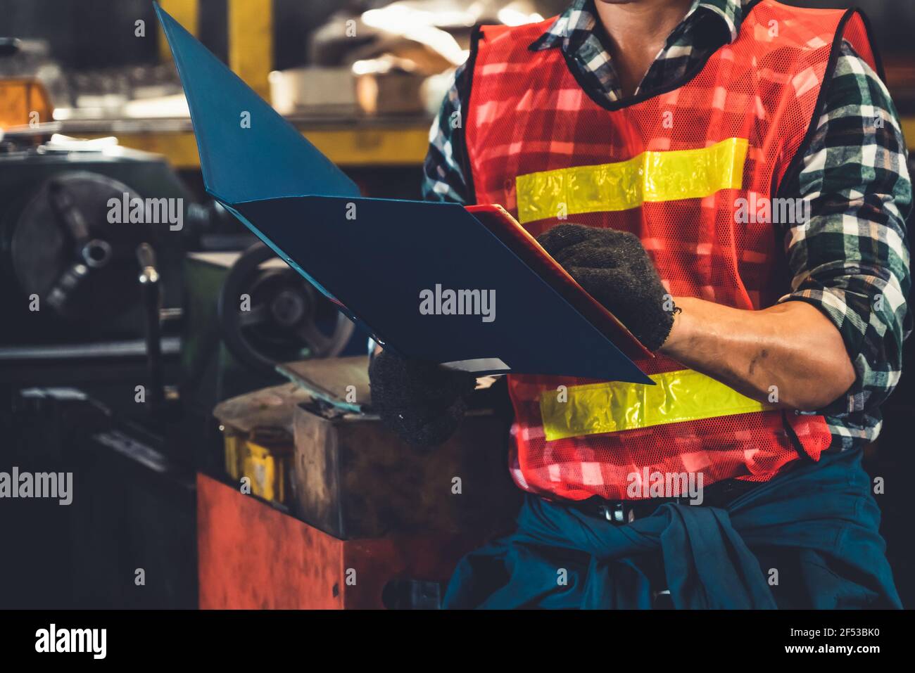 Manufacturing worker working with clipboard to do job procedure ...