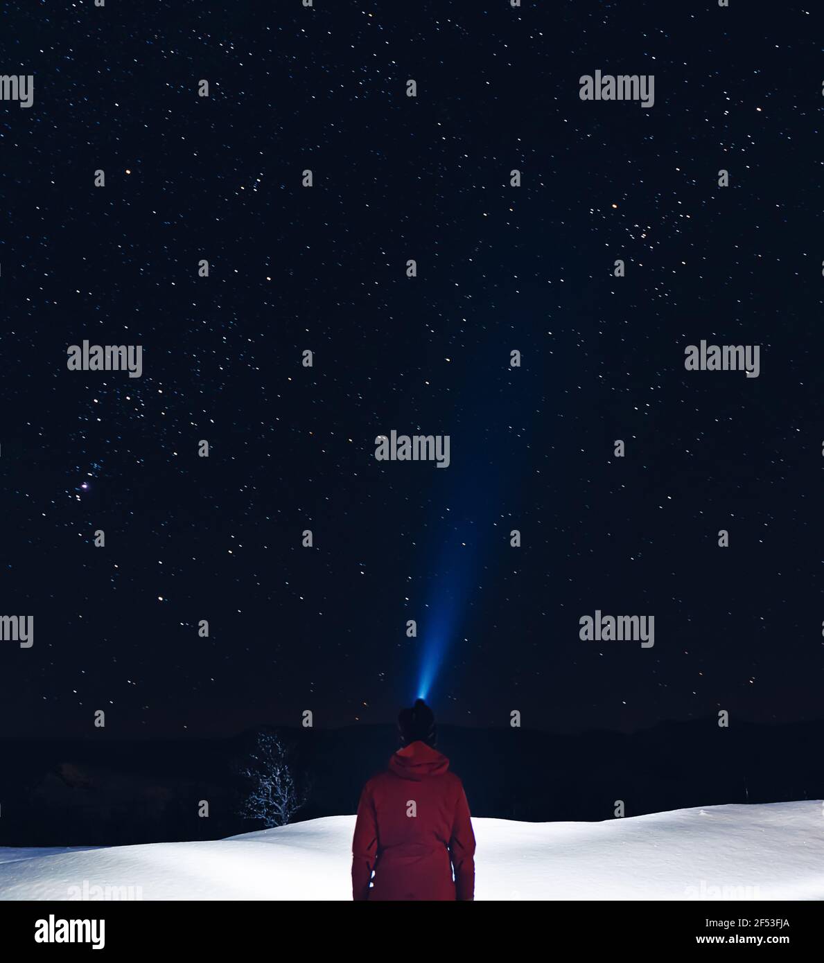 Person lighting up the starry night sky with a head torch while ...