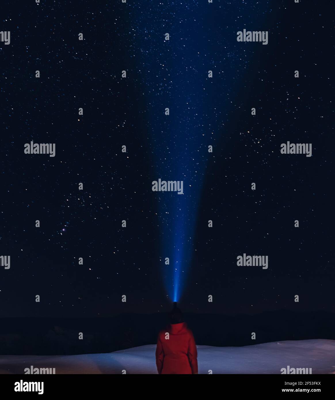 Person lighting up the starry night sky with a head torch while ...