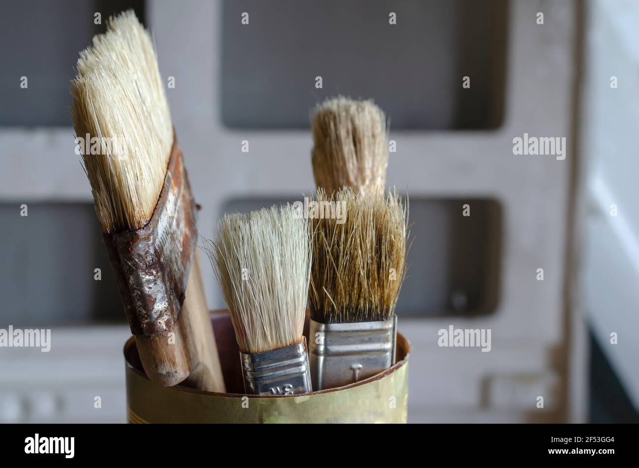 Close-up of old paint brushes standing upright. Four random brushes of ...