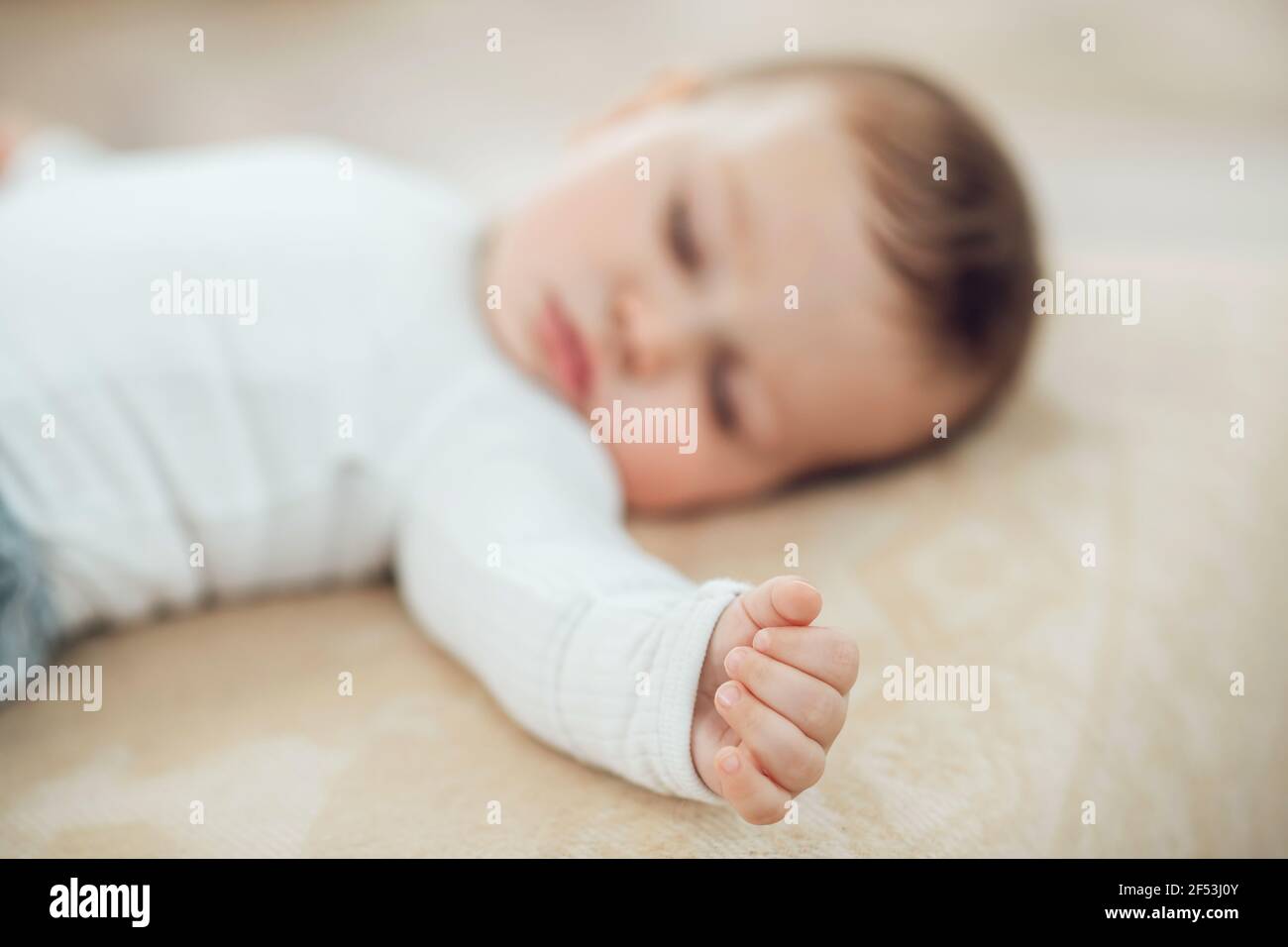 Hand of child lying asleep on bed Stock Photo - Alamy