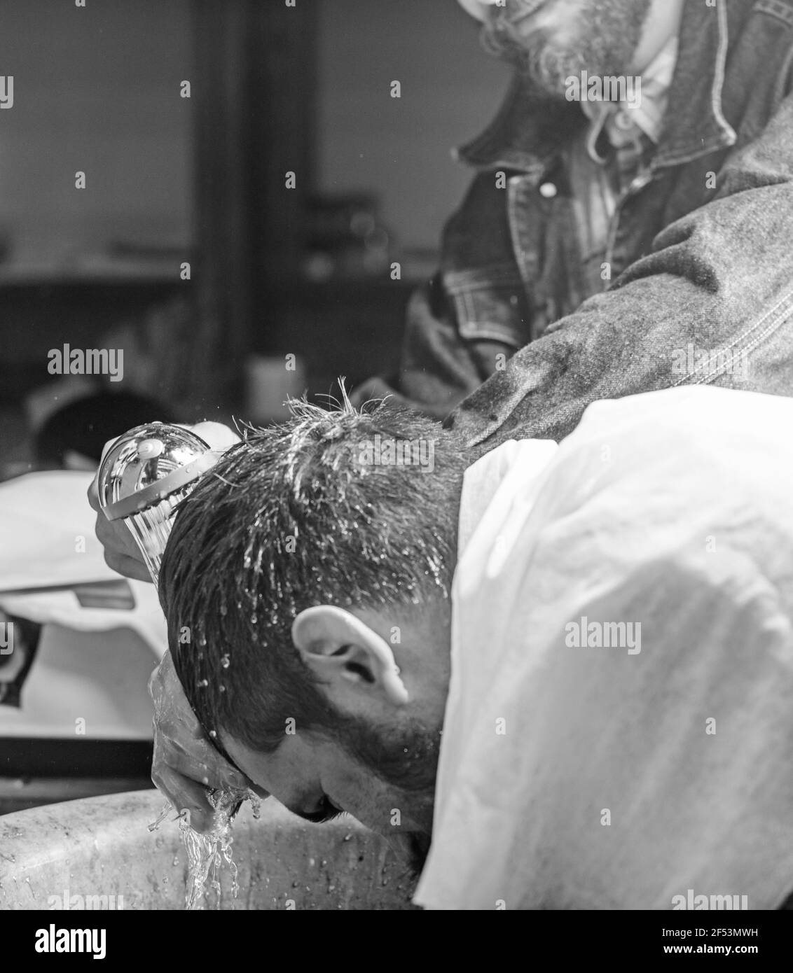 Man with beard and mustache with towel on shoulders, male hands with ...