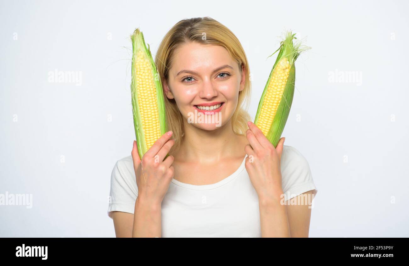 Woman hold yellow corn cob on white background. Girl playful mood hold ...