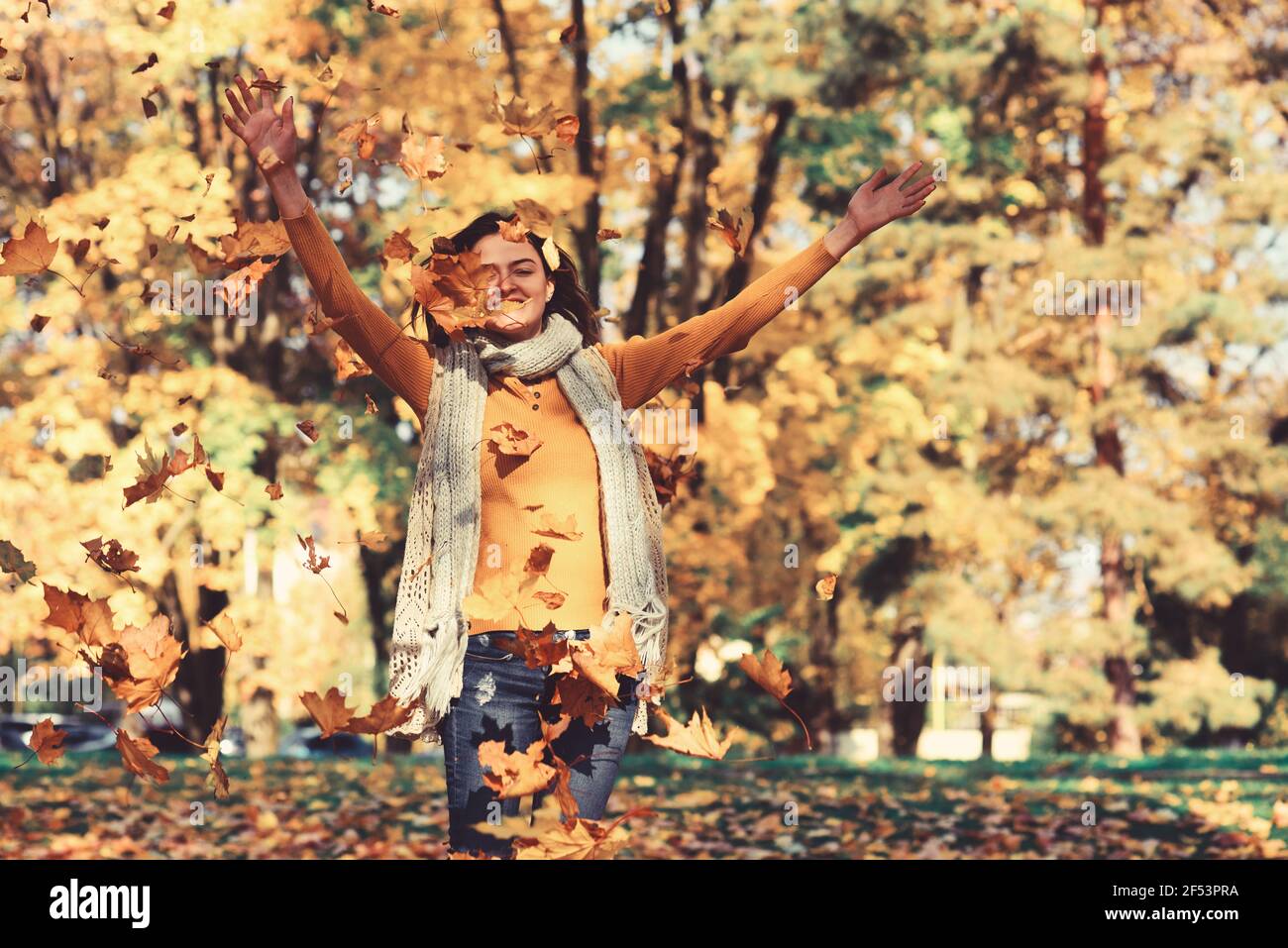 Autumn leaves falling on happy young woman Stock Photo - Alamy