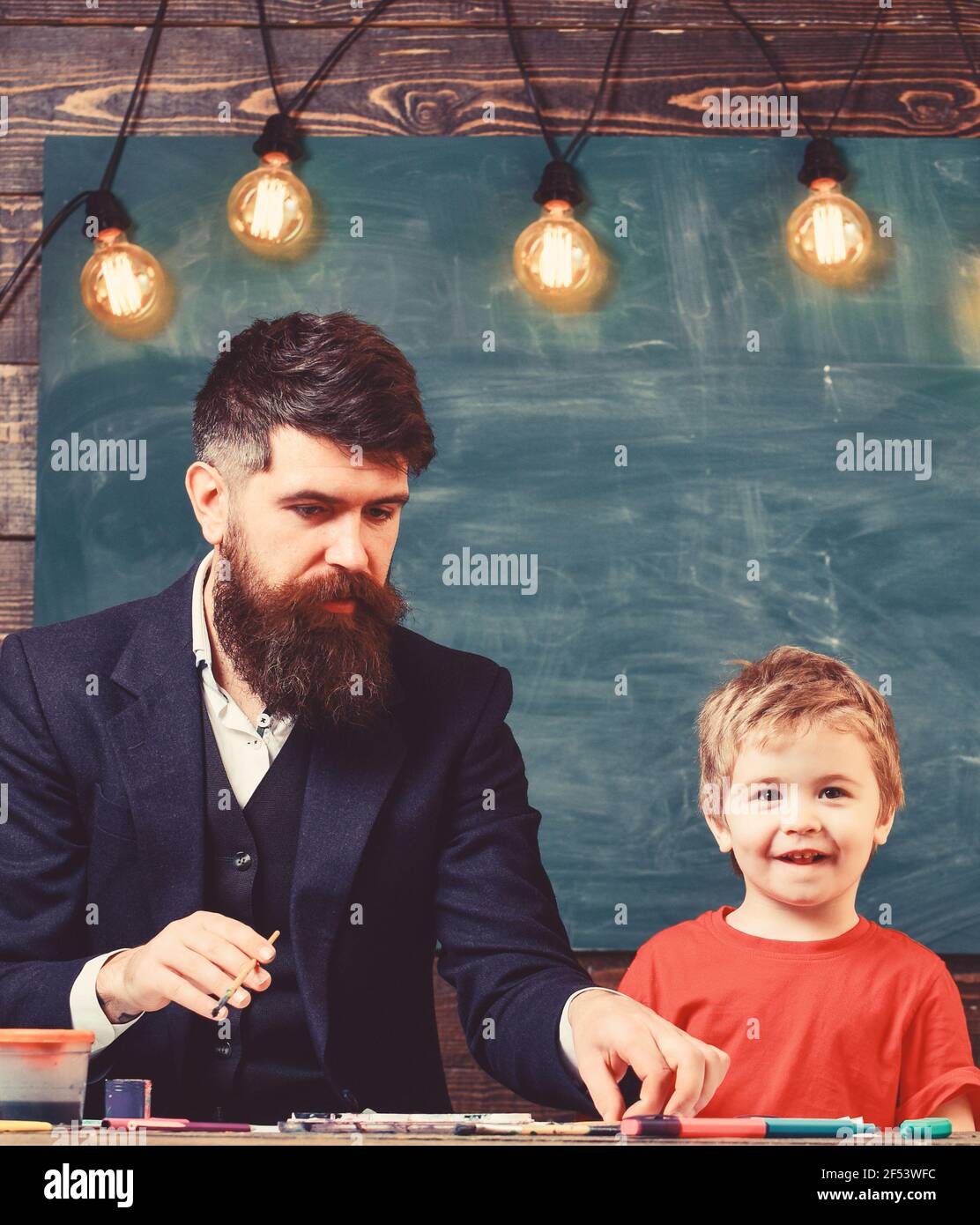 Dad and kid having fun at art class. Daddy and son painting together ...
