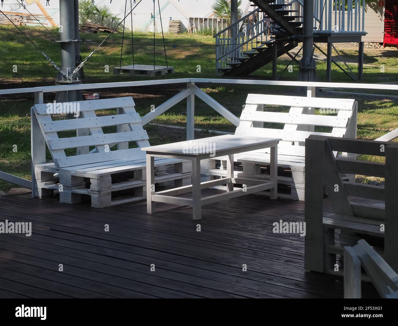 White bench and table from old wooden warehouse pallets stand on wooden ...