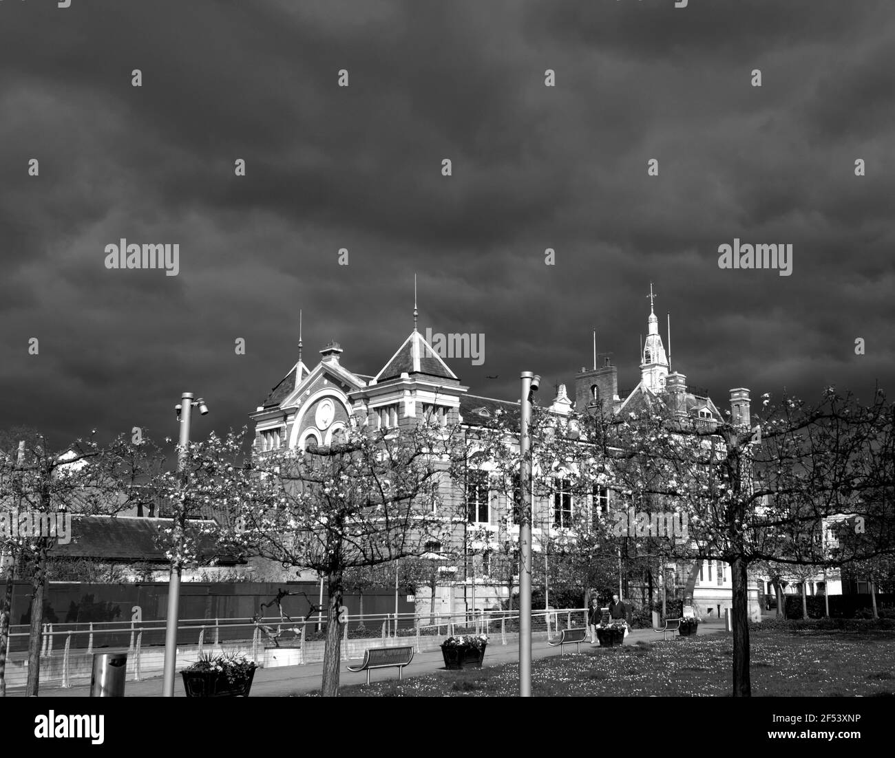 Staines Town Hall, Surrey, UK, in sunshine with a brooding stormy sky ...