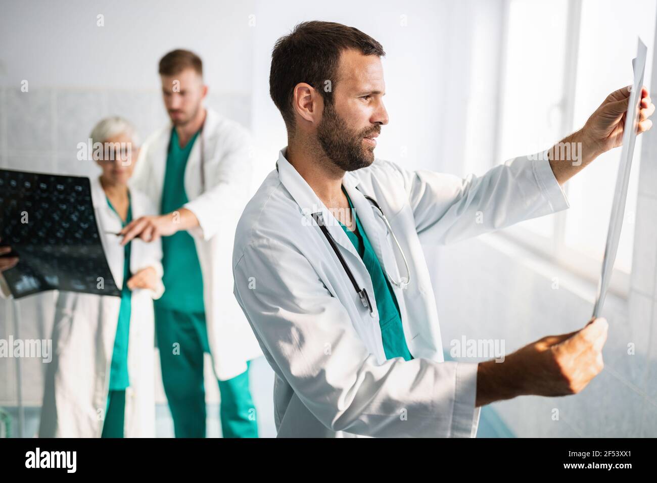 Doctors discussing patient's diagnosis looking at x-rays in a hospital ...