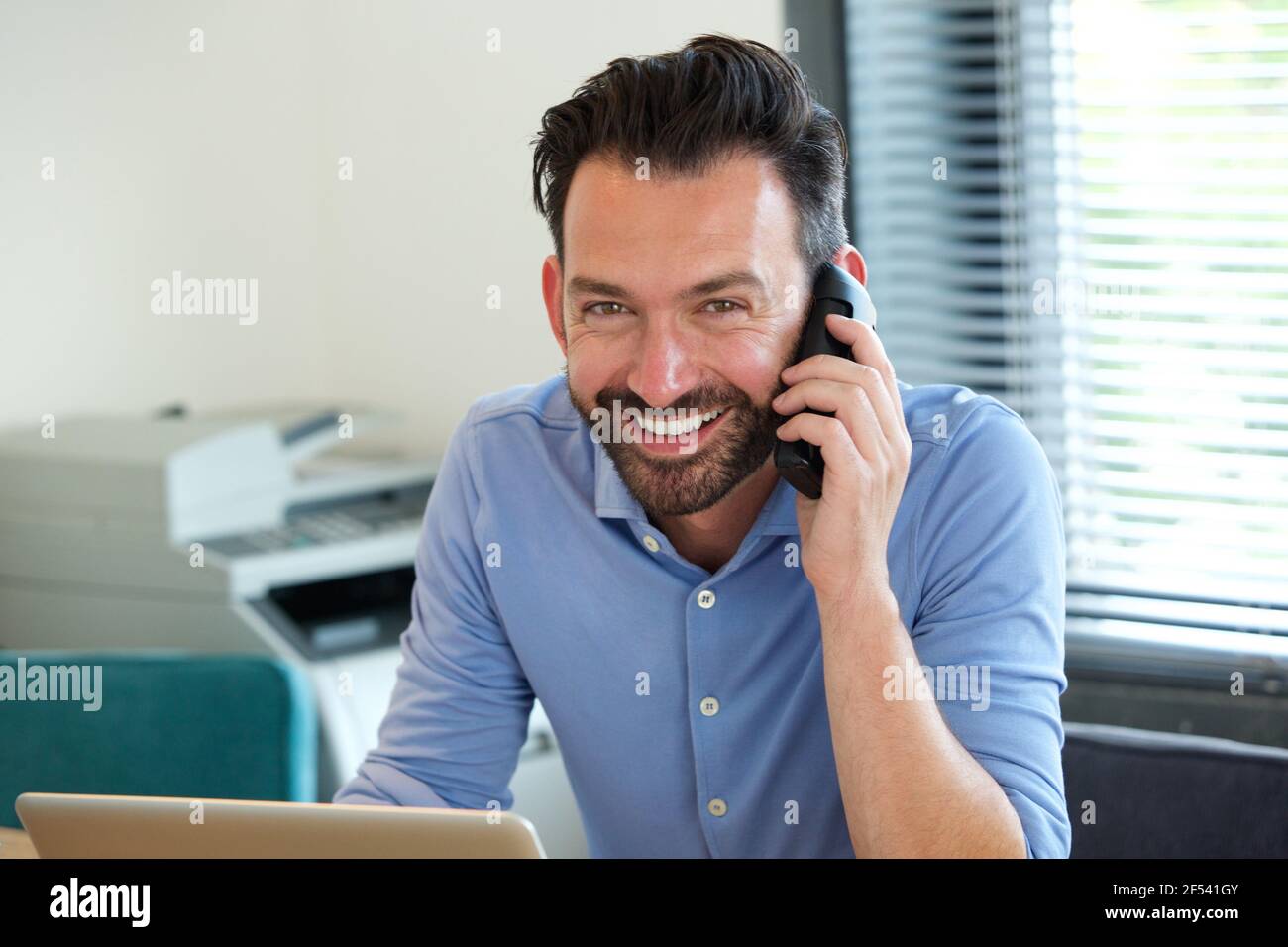 Close up portrait of confident mature guy talking on mobile phone and ...