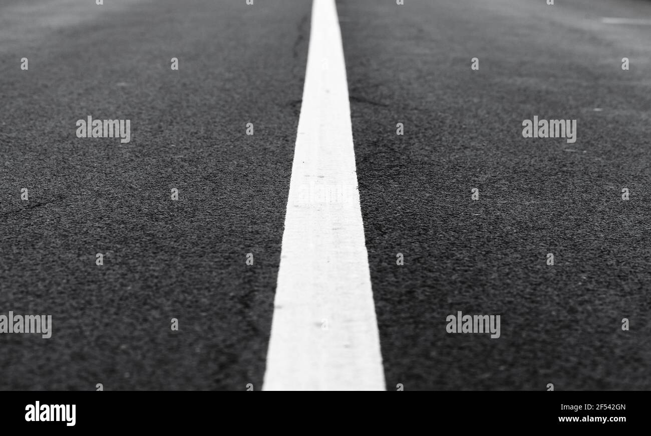 White dividing line, perspective view of highway road marking over dark ...