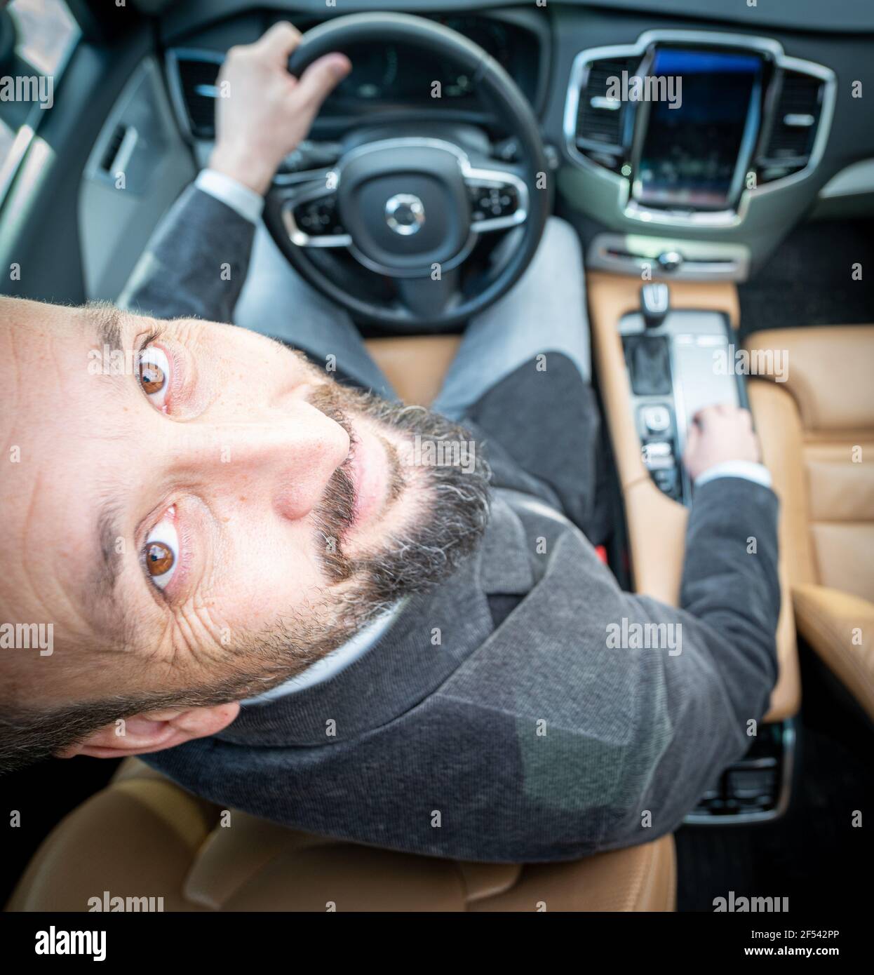 Funny wide angle of a male driver in luxury car Stock Photo - Alamy