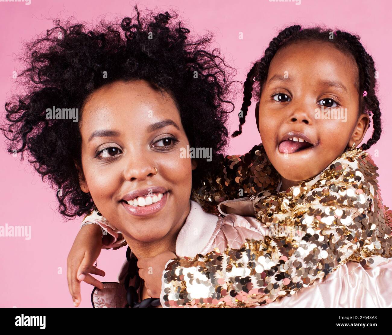 young pretty african-american mother with little cute daughter hugging ...
