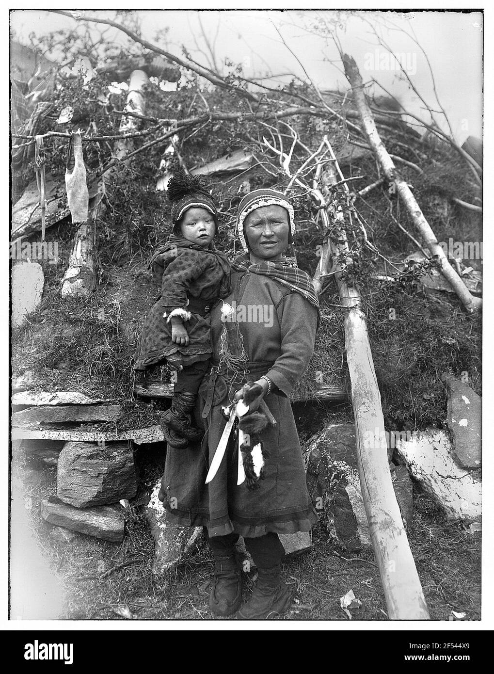 Seed mother with child in front of her ground block hut at Tromsø ...
