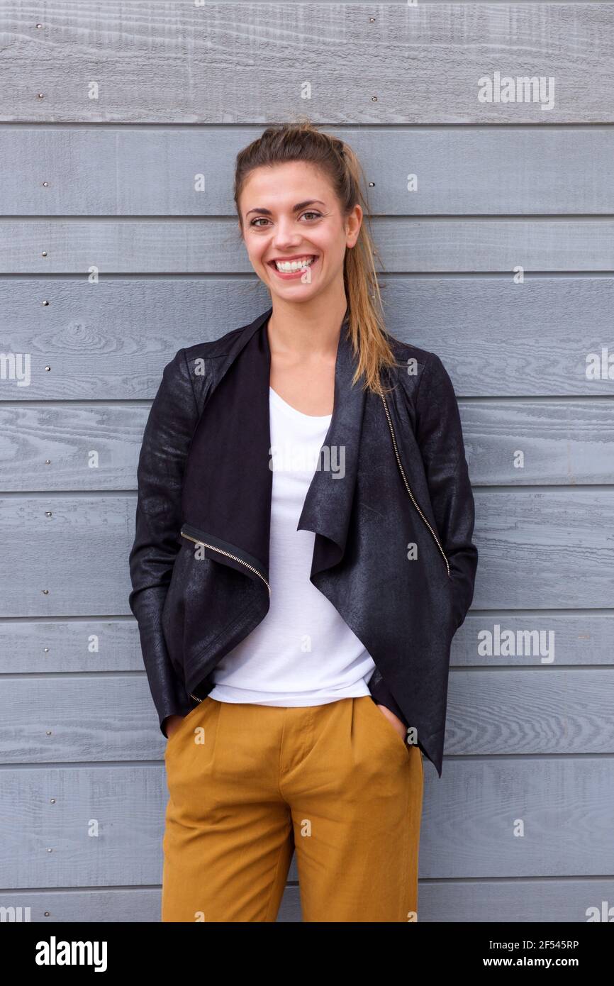 Portrait of beautiful smiling woman in ponytail wearing leather jacket ...