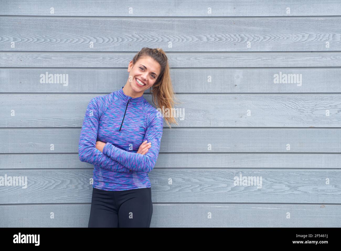 Portrait of smiling active woman standing with arms crossed Stock Photo ...
