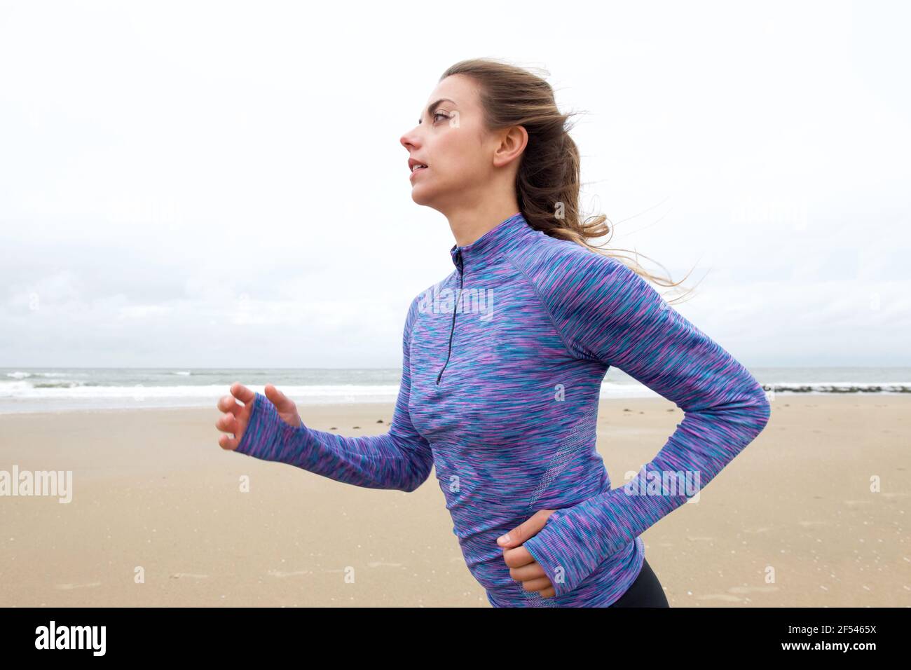 Profile portrait of serious athletic woman running of beach Stock Photo ...