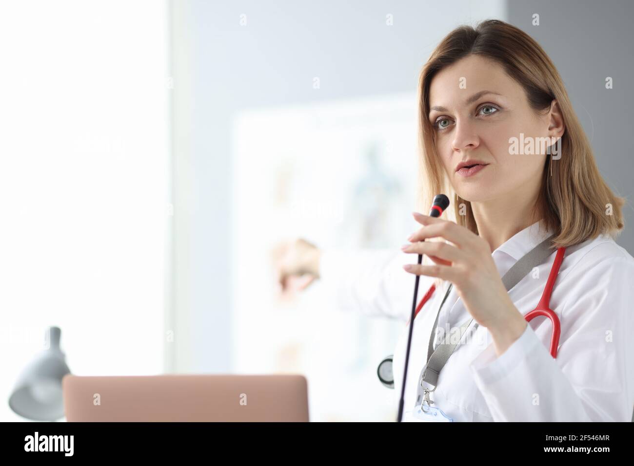 Doctor speaking into microphone at training seminar Stock Photo - Alamy
