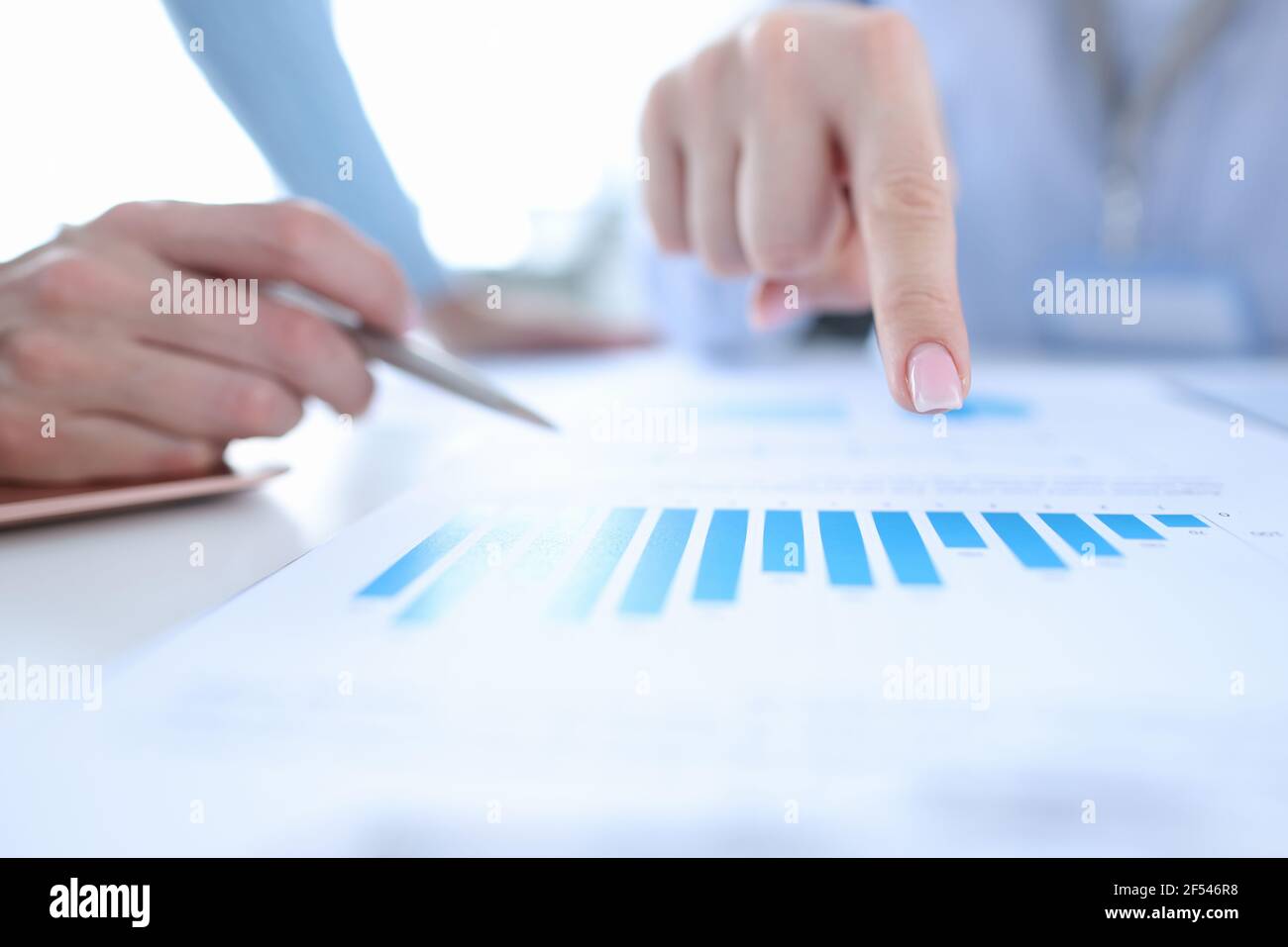 Female finger pointing to graph in document closeup Stock Photo - Alamy