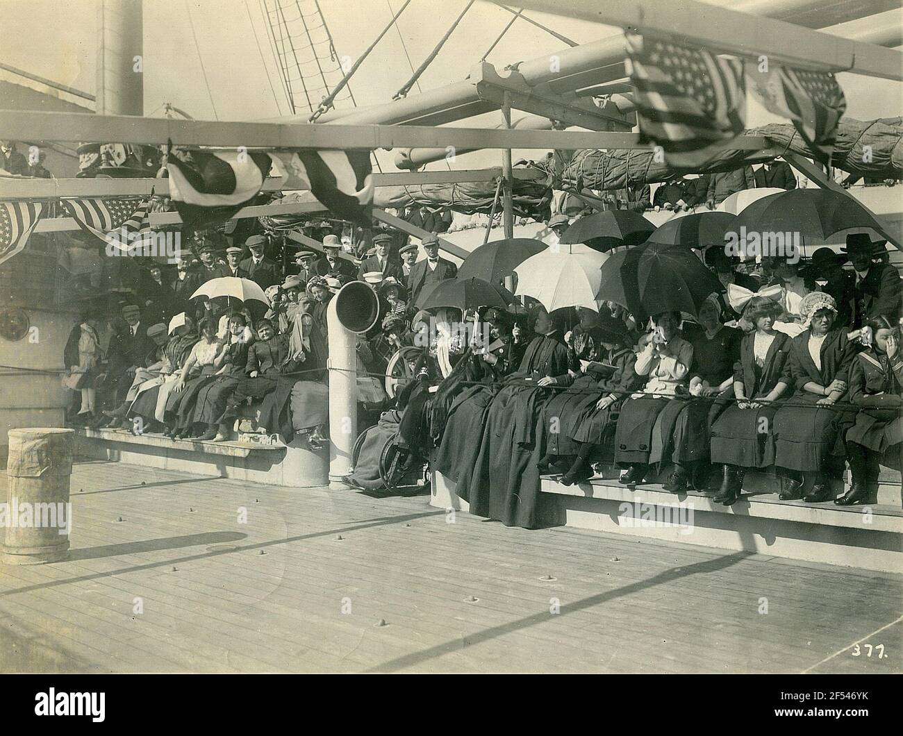 Spectators with umbrellas on on top of the deck of the passenger ...