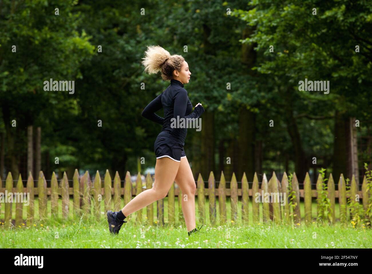 Full length side portrait of young female runner outside Stock Photo ...