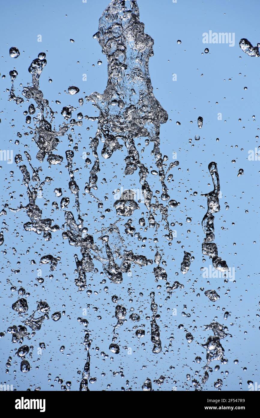 Close up water drops of fountain stream splash over background of clear ...
