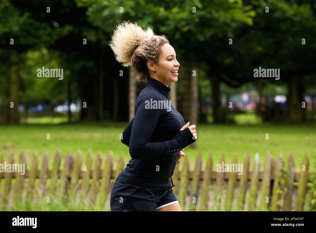 Side profile portrait of female runner outside smiling Stock Photo - Alamy