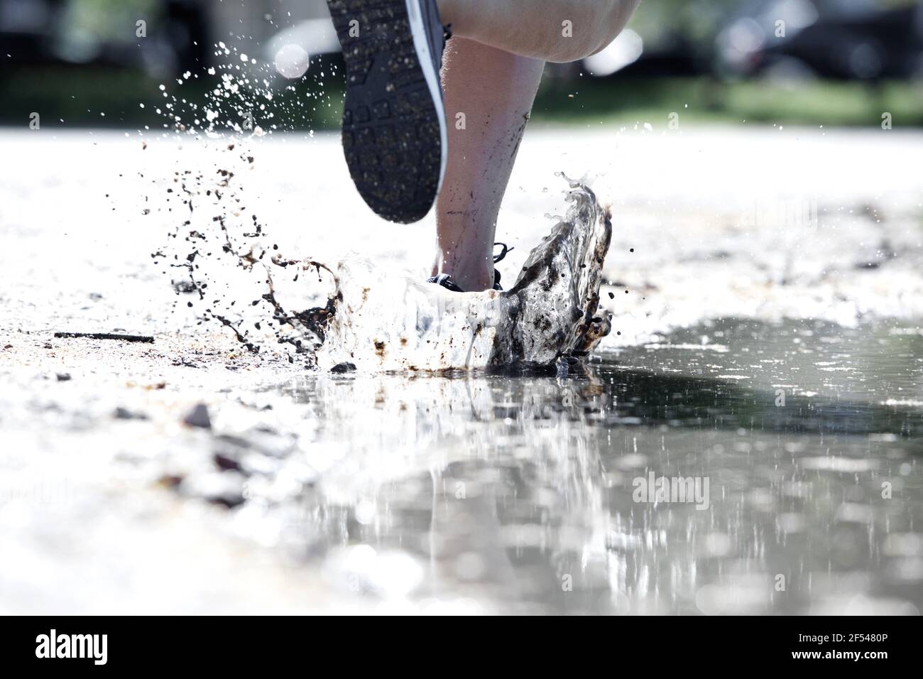 Close up low angle runner splash in puddle Stock Photo - Alamy