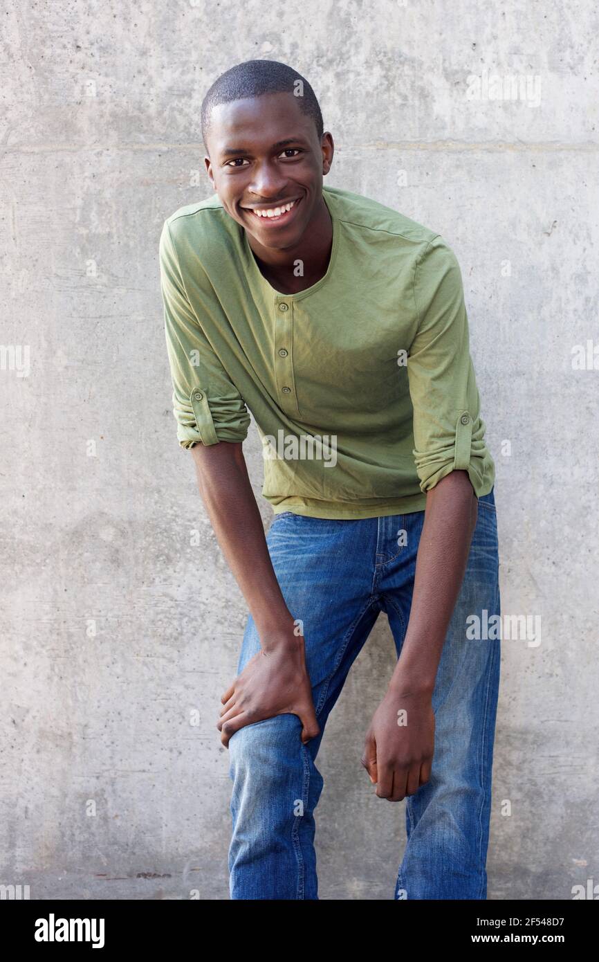 Portrait of happy young african male model posing against wall Stock ...