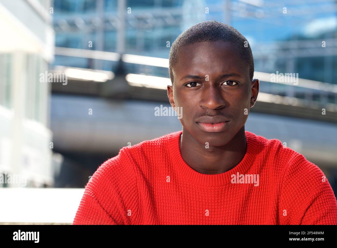 Portrait of young african man sitting outdoors looking serious Stock ...