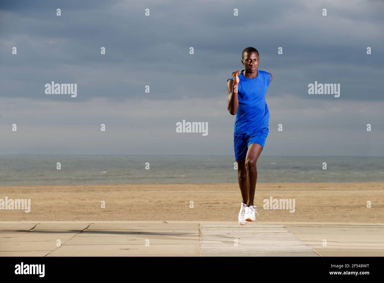 Full body portrait of young african man running on beach Stock Photo ...