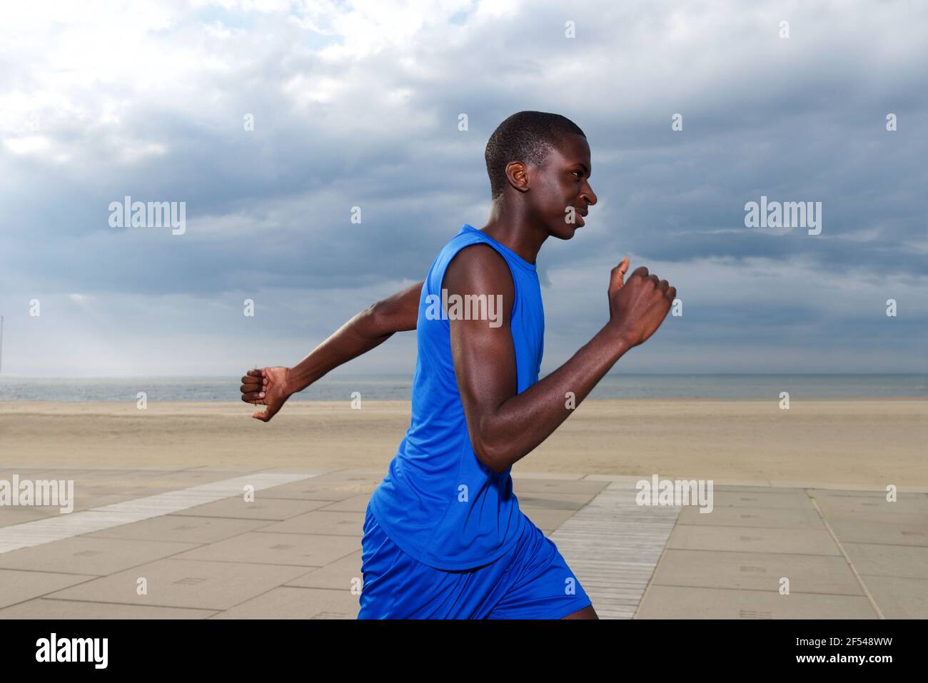 Portrait of healthy young african american man jogging at beach Stock ...