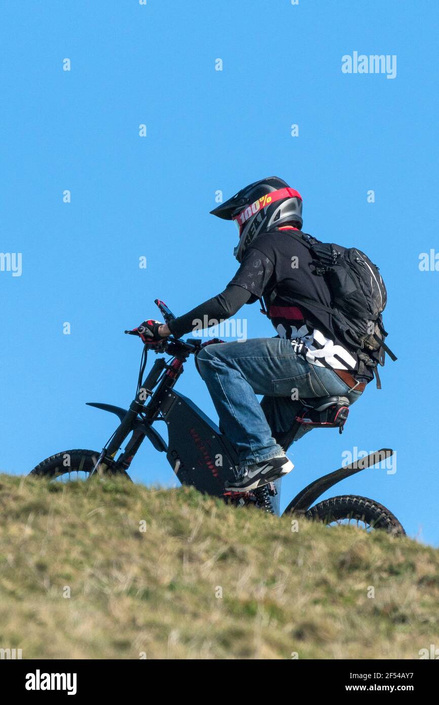 A cyclist riding uphill on an electric mountain bike Stock Photo - Alamy