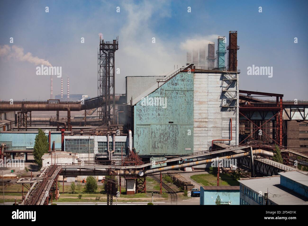 Main industrial building of metal alloy plant. Blue sky background ...