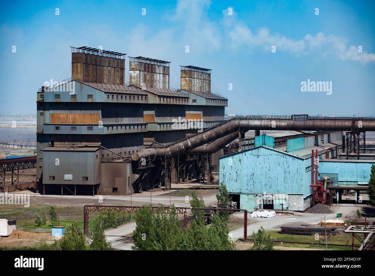 Main rusted industrial building of metal alloy plant with chimneys ...