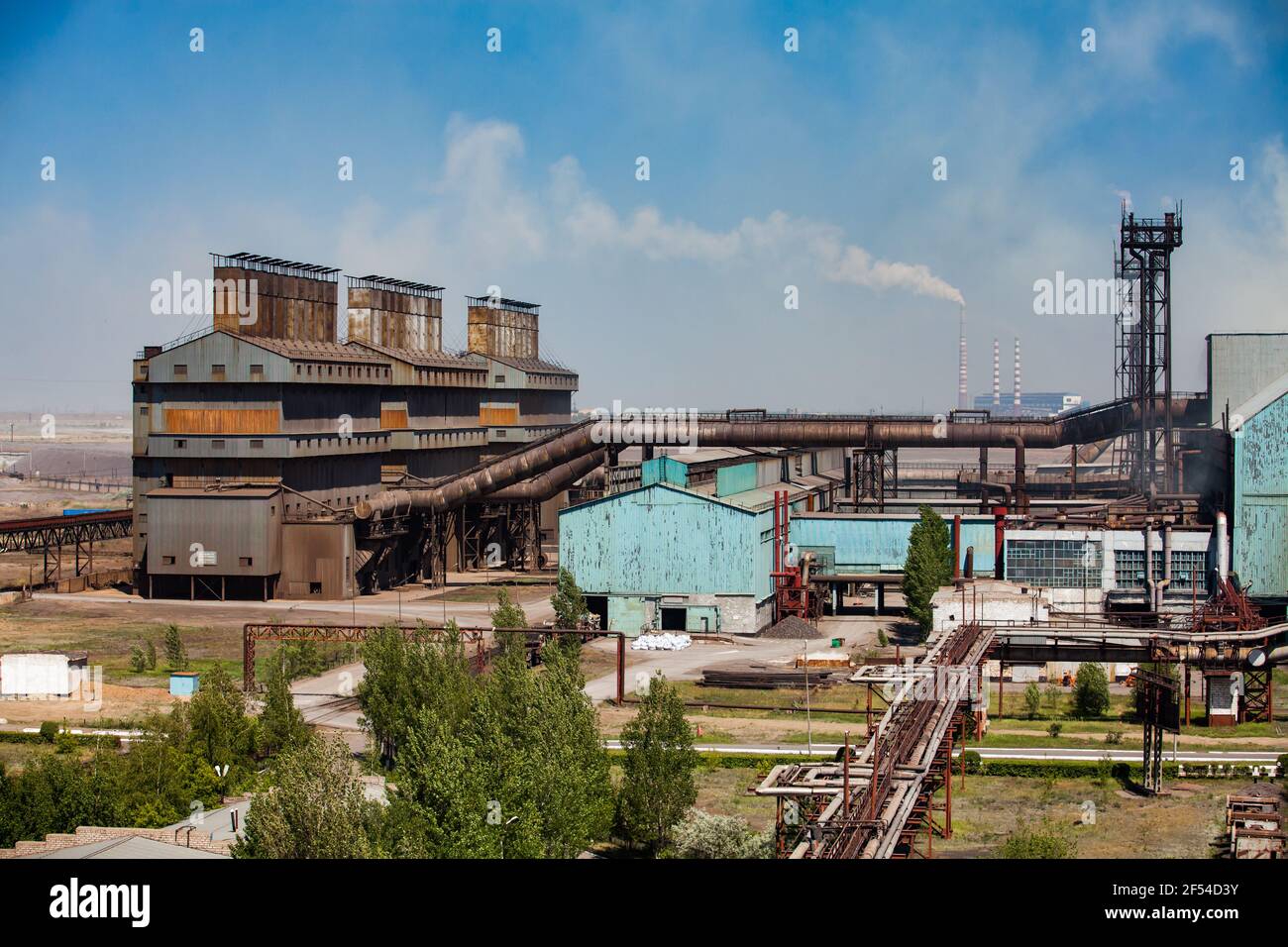 Main industrial building of metal alloy plant. Blue sky background ...