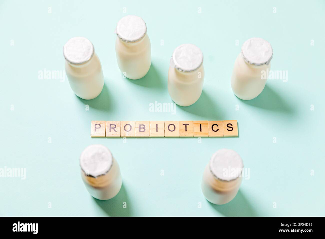 Small bottles with probiotics and prebiotics dairy drink on blue ...