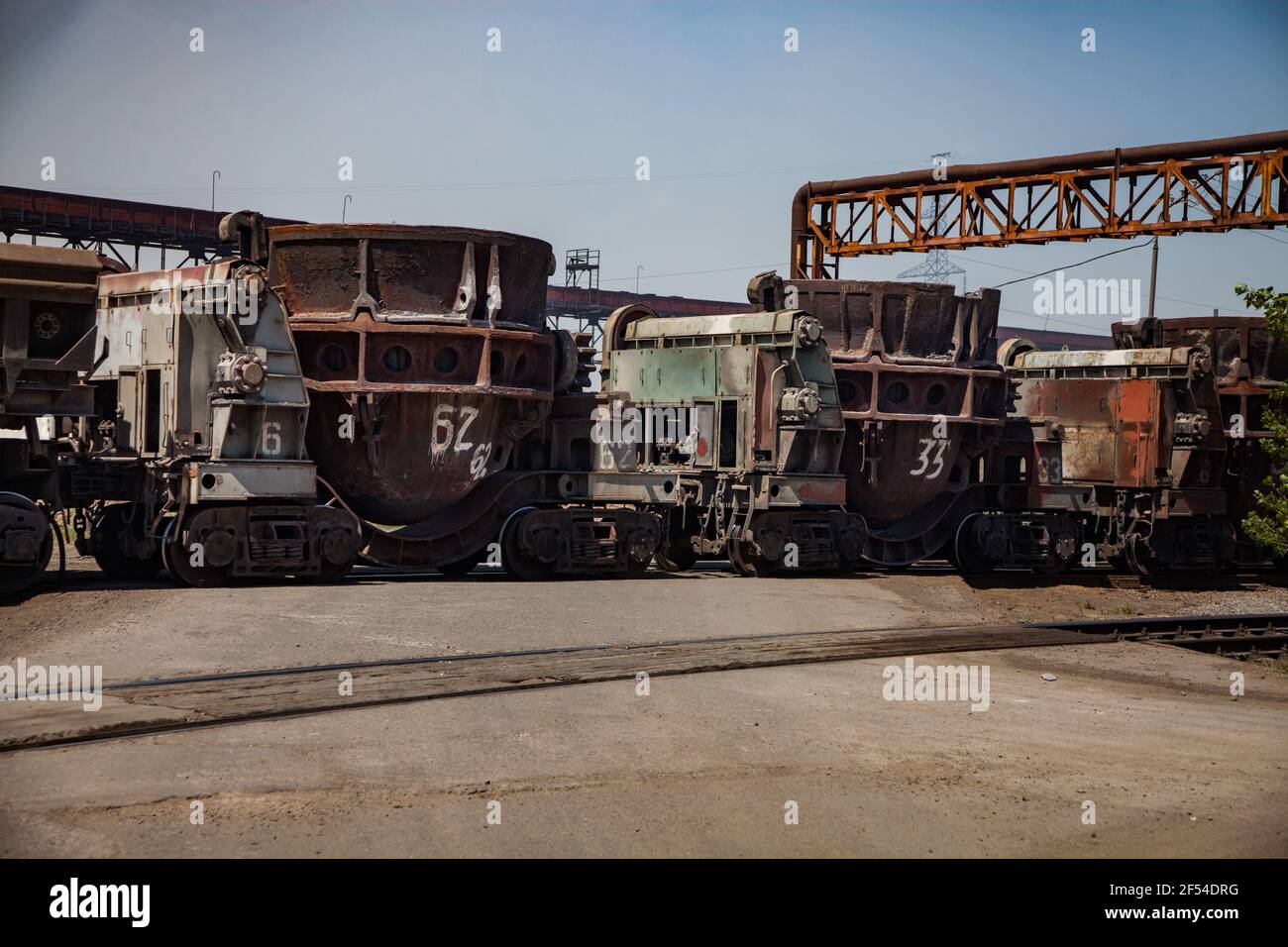 Metallurgical plant railroad station. rusted slag cars on tracks. Blue ...