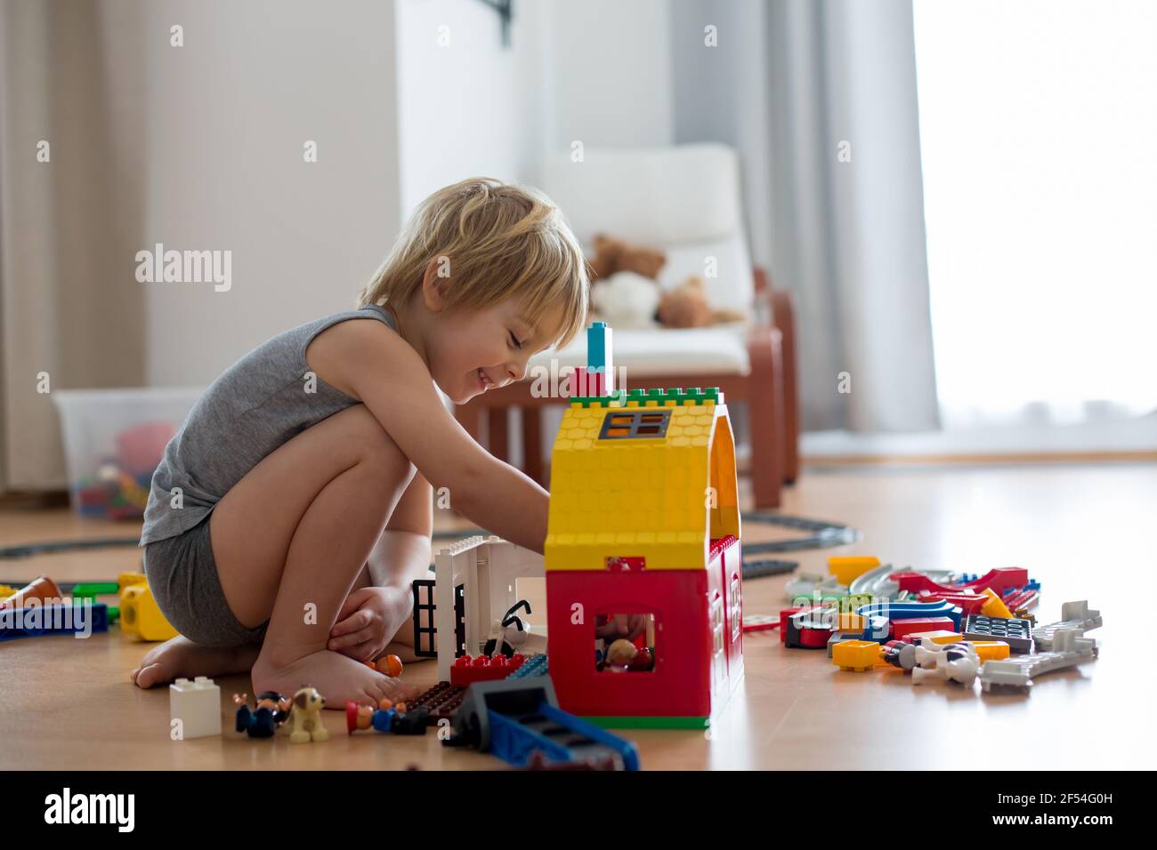 Cute child, playing with colorful toy blocks. Little boy building house ...