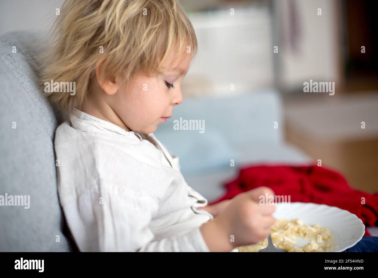 Cute toddler boy, eating pasta with white cheese at home for lunch ...